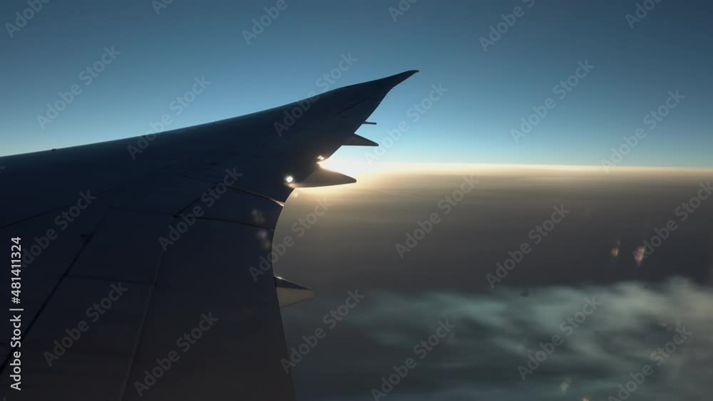 Airplane Wing and jet streams in flight from window, sunset sky, jet ...