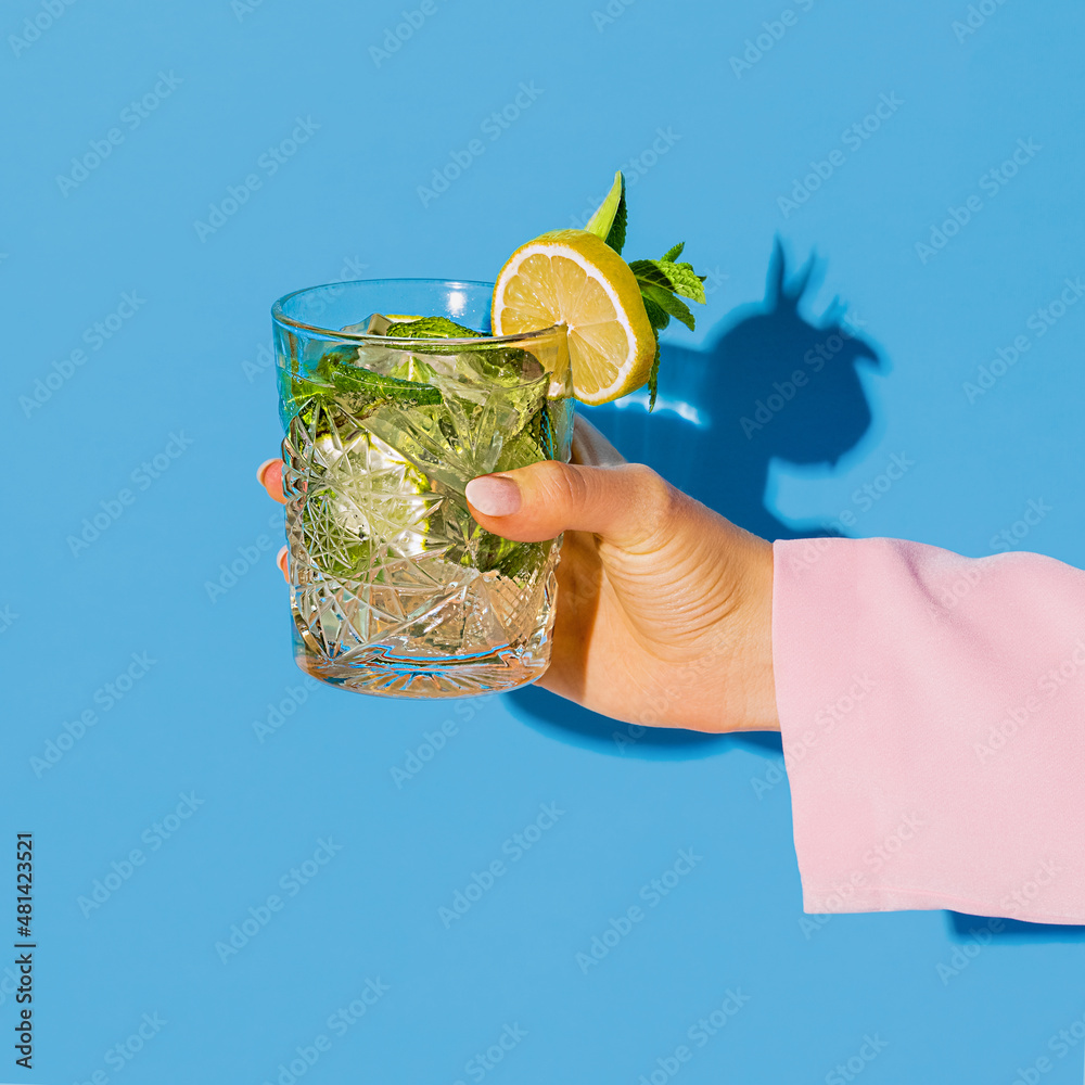 Female hand holding glass with cocktail mojito with lemon isolated on ...