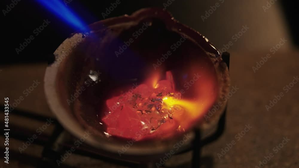 Jewelry manufacturing. Melting gold. Molted metal pouring into bar form ...