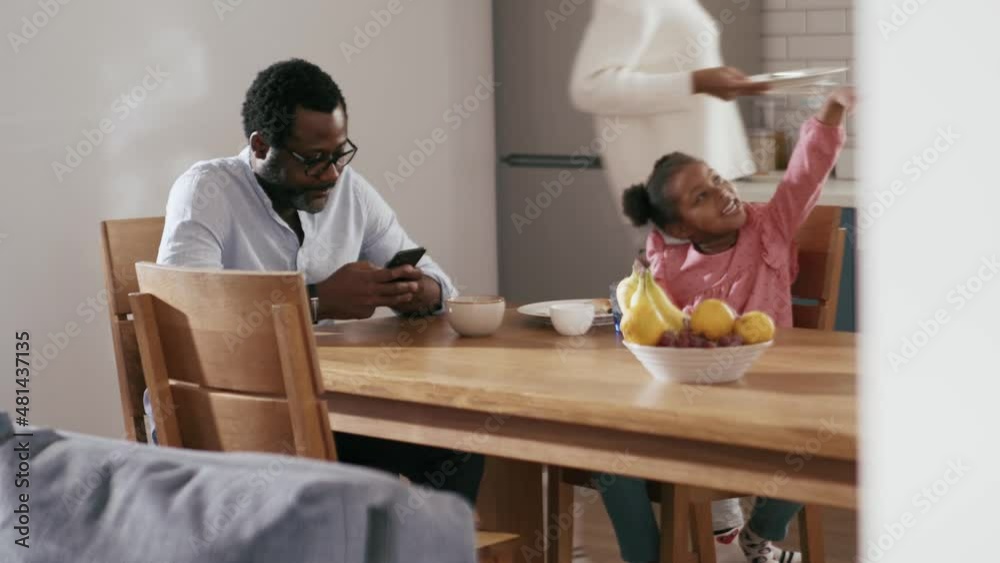 African father and daughter rejoicing after breakfast while mother ...