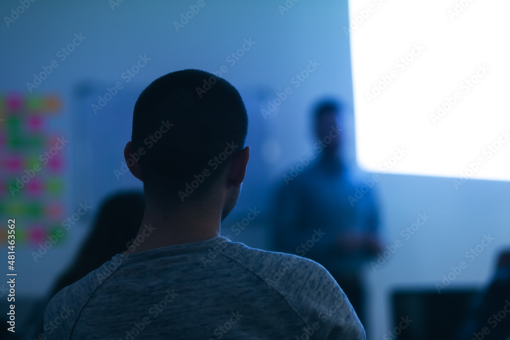 Back view of students during class during lecture. Professor next to a ...