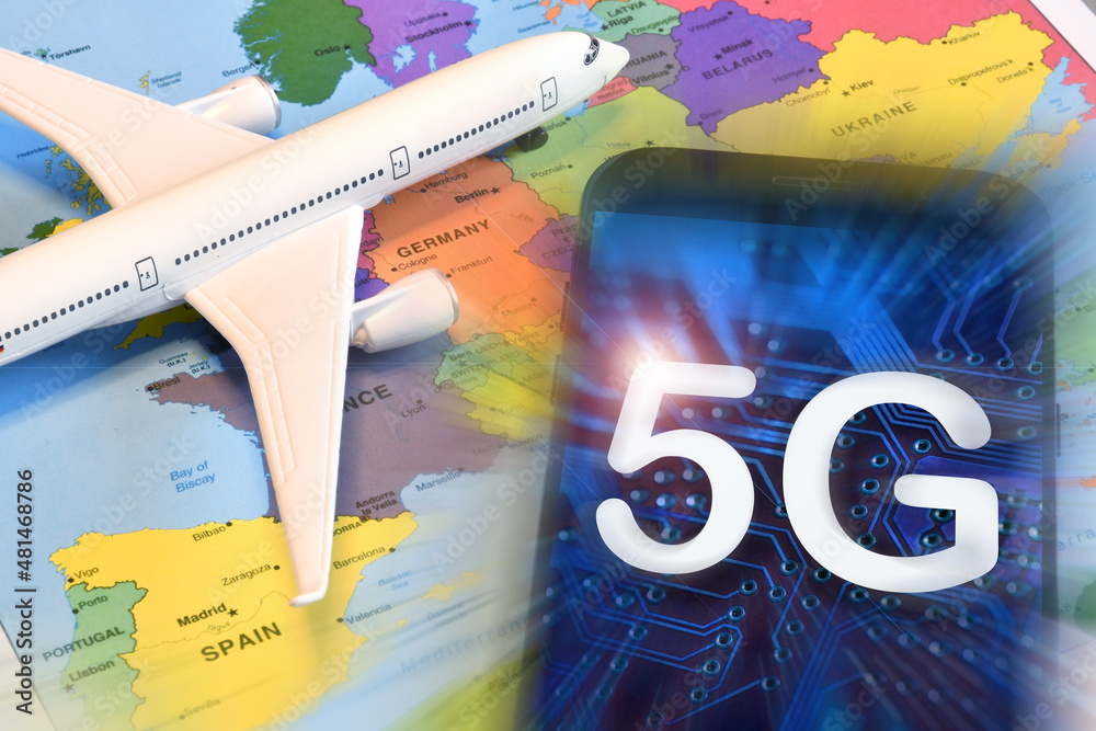 Model airplane on geographic map and smartphone with 5G text on screen ...