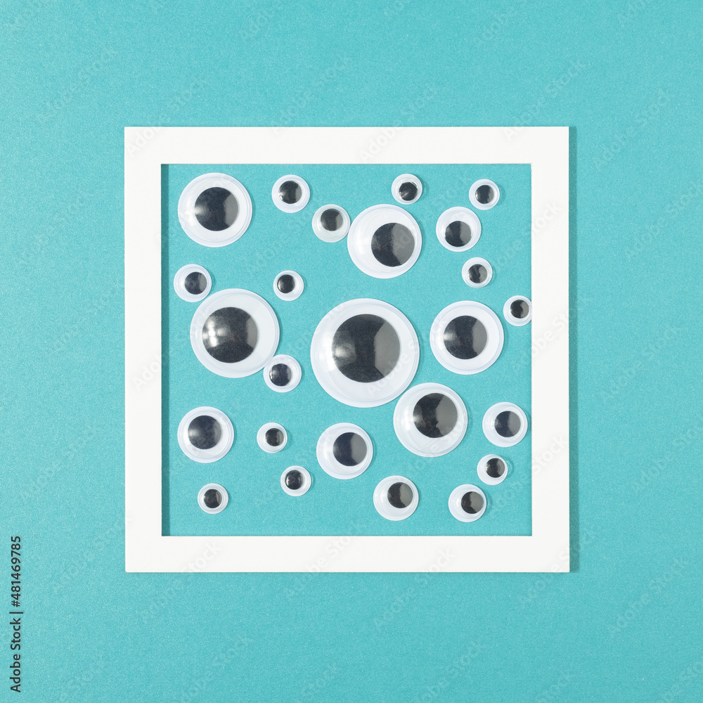 Sticker eyes in various sizes in a square frame on a pastel blue ...