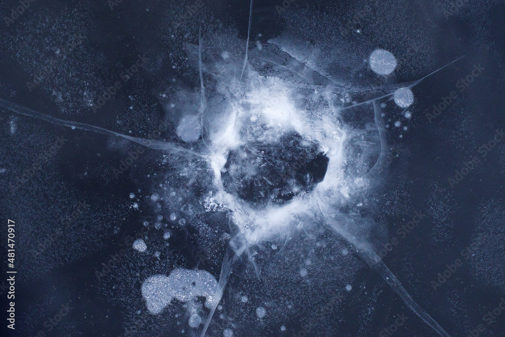 Cracks and air in the ice around a frozen hole in the surface of a ...