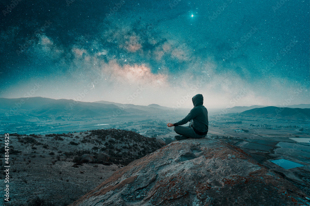person sitting on the top of the mountain meditating or contemplating ...