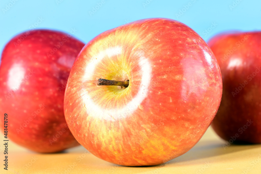 beautiful red apples seen from the side isolated on yellow and blue ...