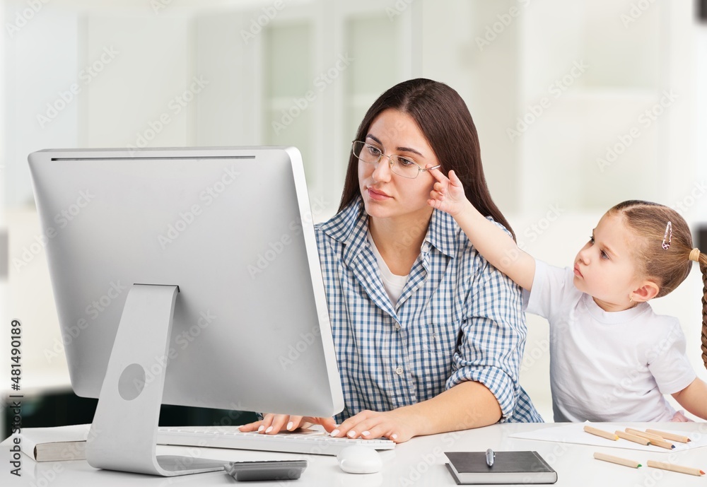 Beautiful young mother working for computer it home with little spoiled ...