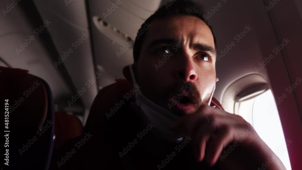 Closeup view of caucasian male passenger of the airplane pulling down ...