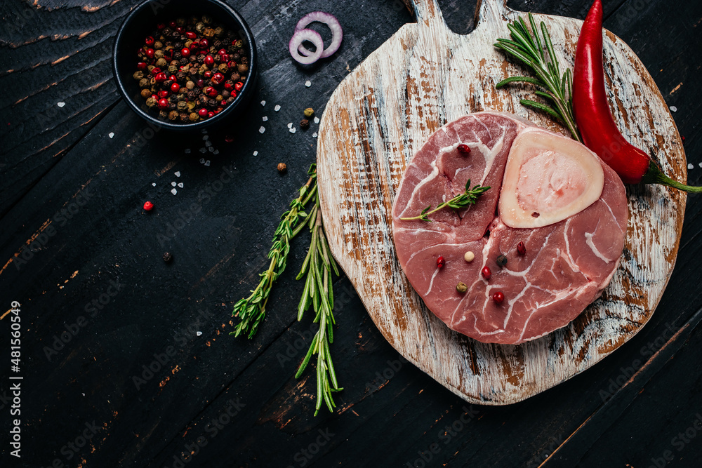 Raw Ossobuko steak marble meat with herbs and spices on dark background ...
