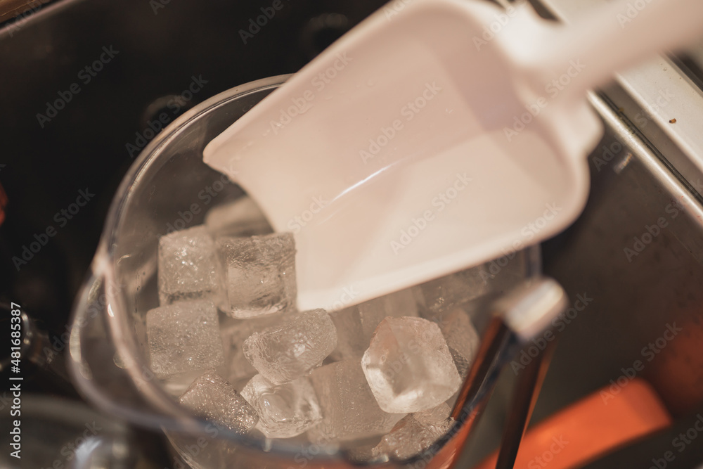 Barista with scoop taking ice cubes from container Stock Photo | Adobe ...