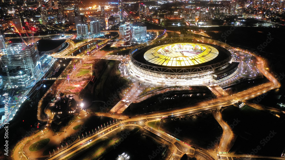 Aerial drone night shot of iconic illuminated London Stadium facilities ...
