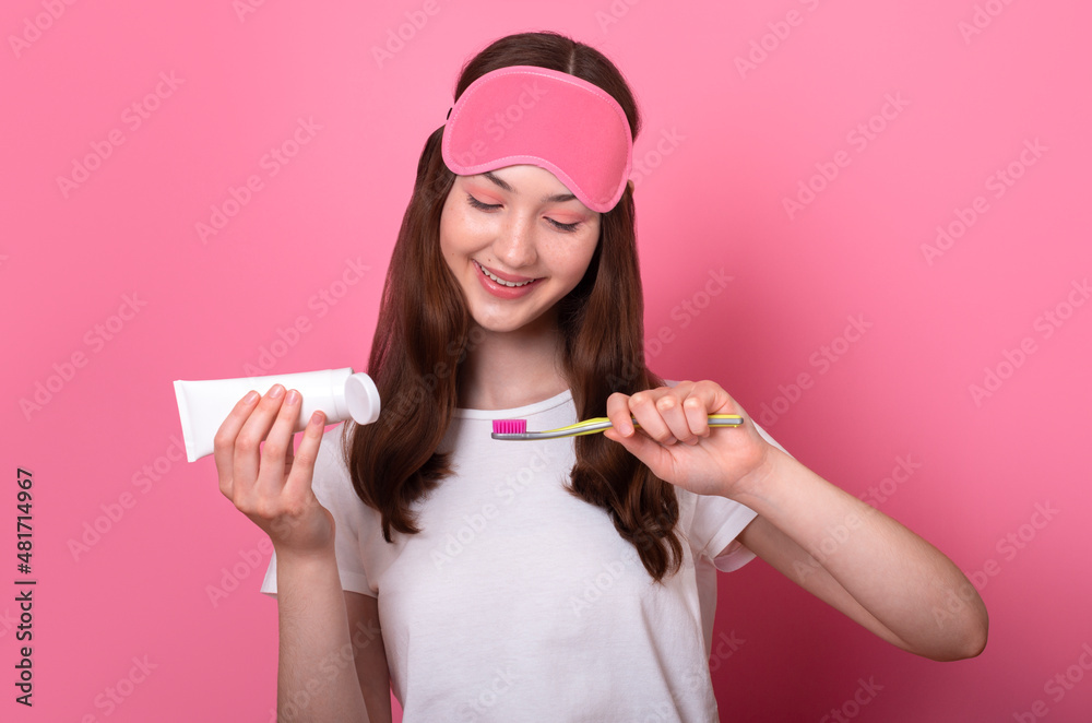 cheerful smiling caucasian brunette girl puts toothpaste on the ...