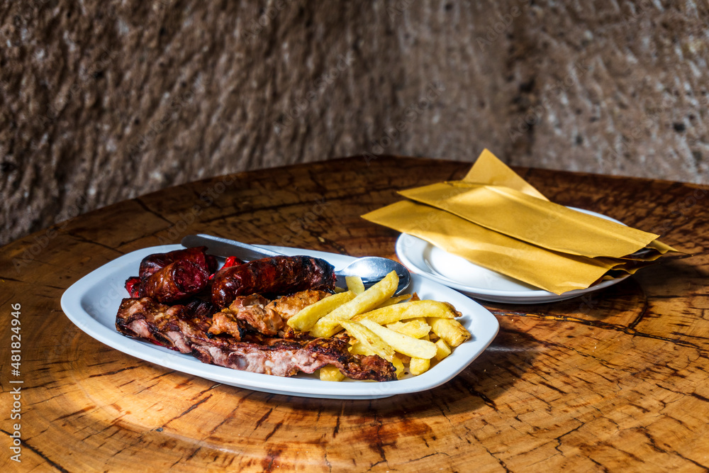 Mixed meat barbecued and served with french fries in restaurant in the ...