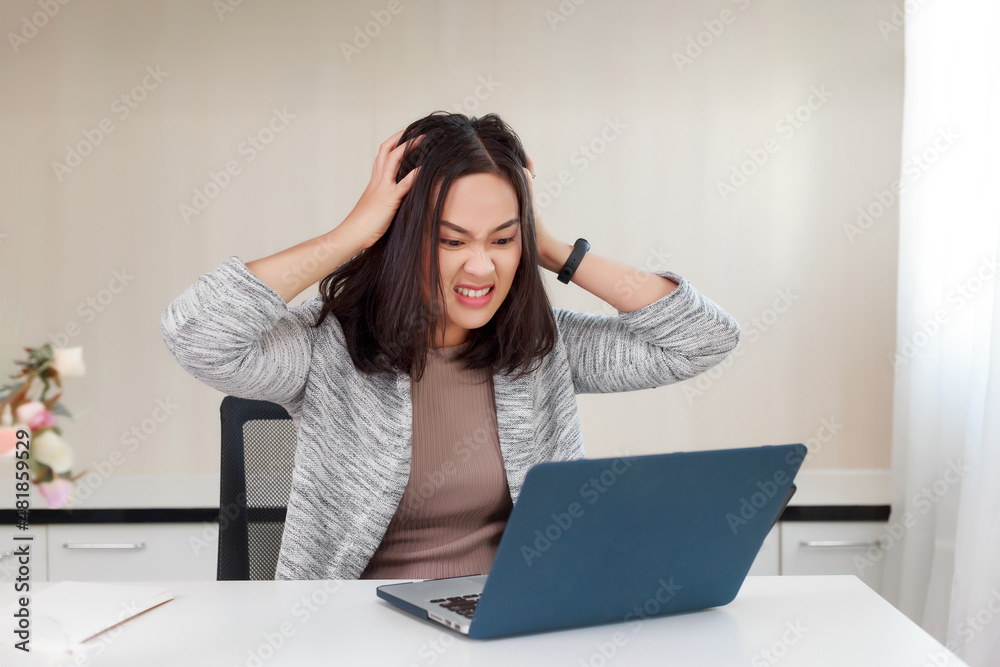 Upset Young Asian business woman having trouble work on laptop computer ...