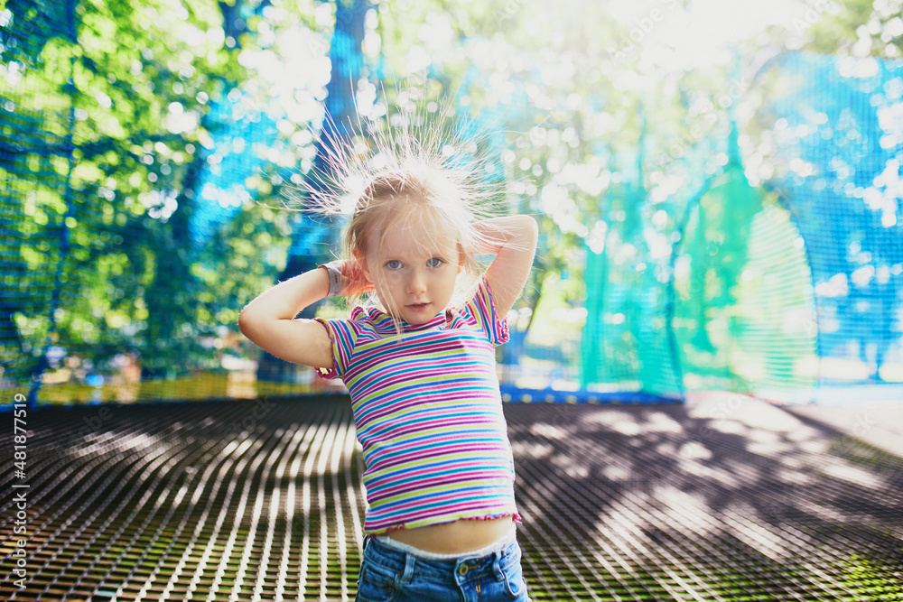 Girl having fun in adventure park. Child with electrified hair on tree ...