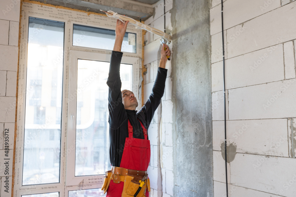 Electrician measuring voltage of air conditioner in construction site ...