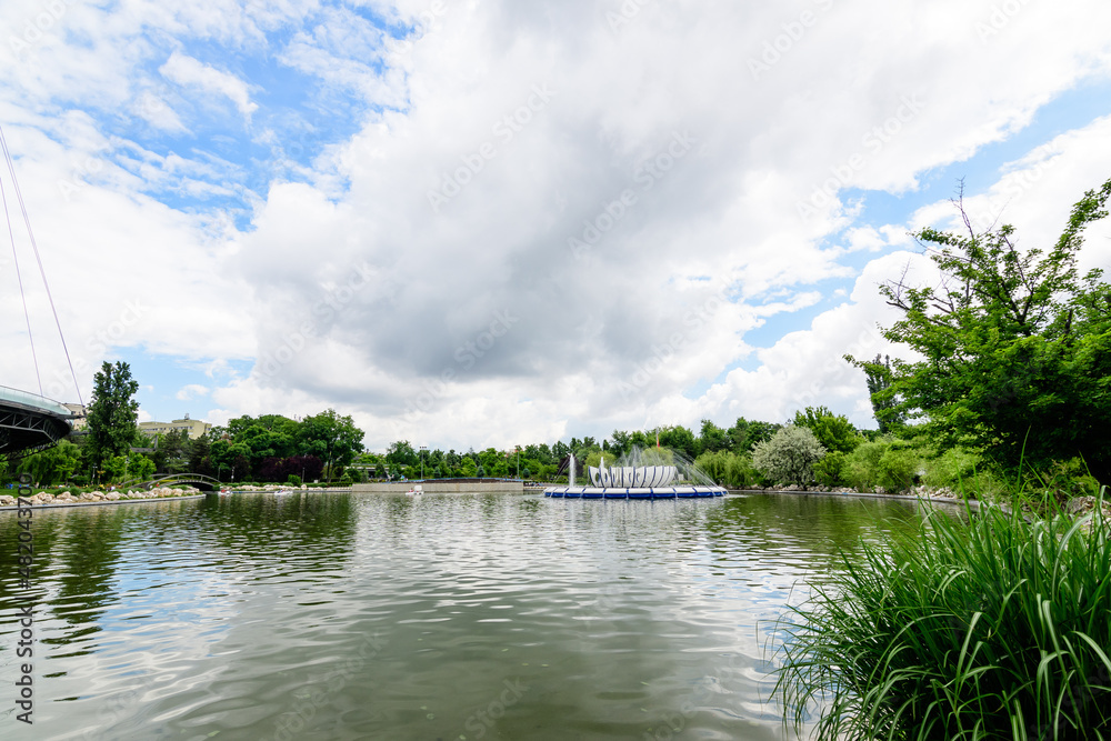 Landscape with lake and vivid green trees in Drumul Taberei Park ...