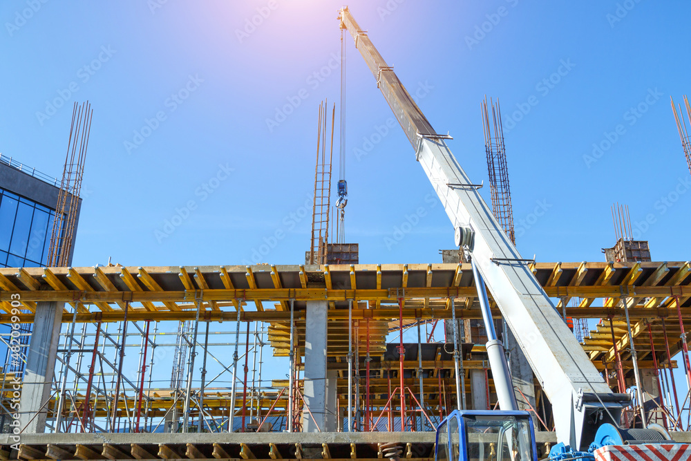 Fotka „Building construction site work against blue sky.Hydraulic ...