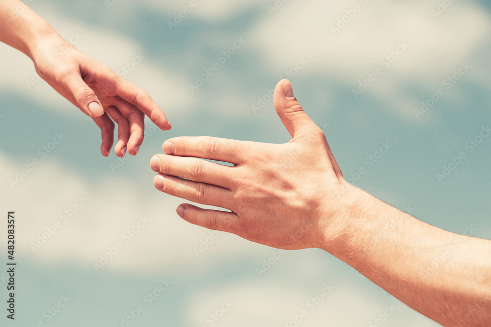 Giving a helping hand. Hands of man and woman on blue sky background ...