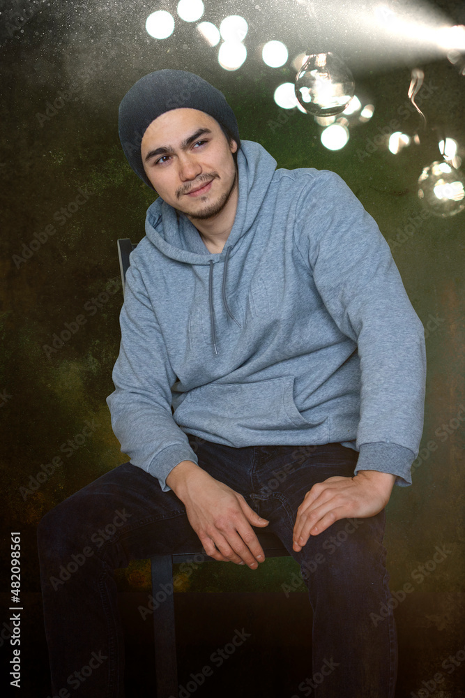 Filipino man sitting in chair gazing off into distance illuminated by ...