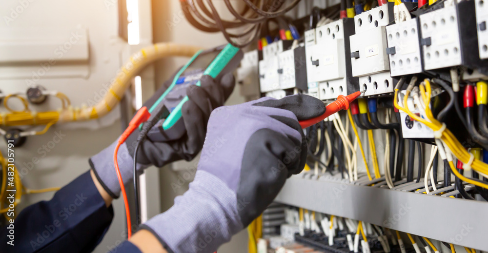 Electrician engineer tests electrical installations and wires on relay ...