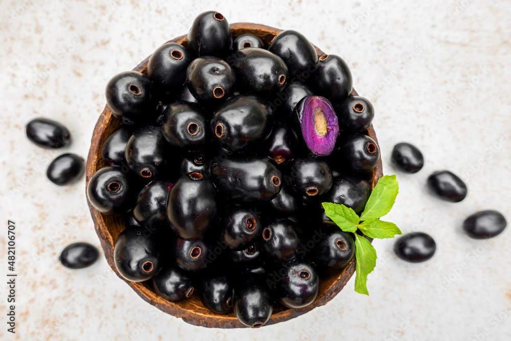 Black ripe Syzygium cumini fruits. Dark black java plum in a wood bowl ...
