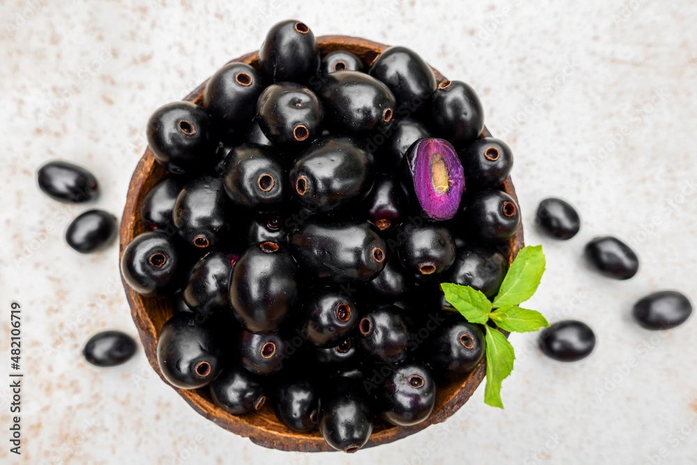 Black ripe Syzygium cumini fruits. Dark black java plum in a wood bowl ...