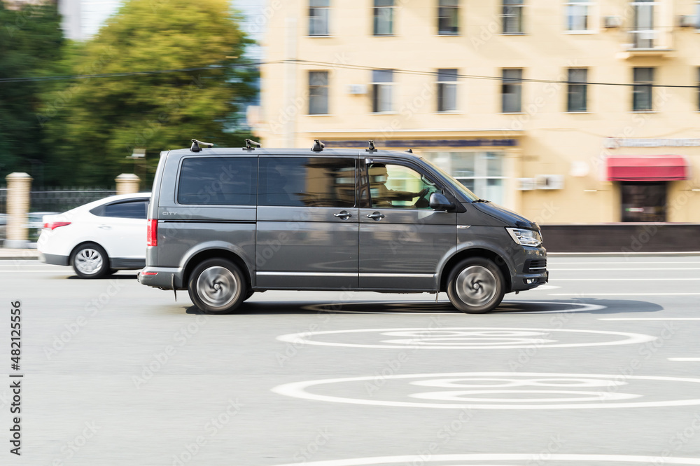 Volkswagen Transporter T6 on the city road. Gray van rides on street ...