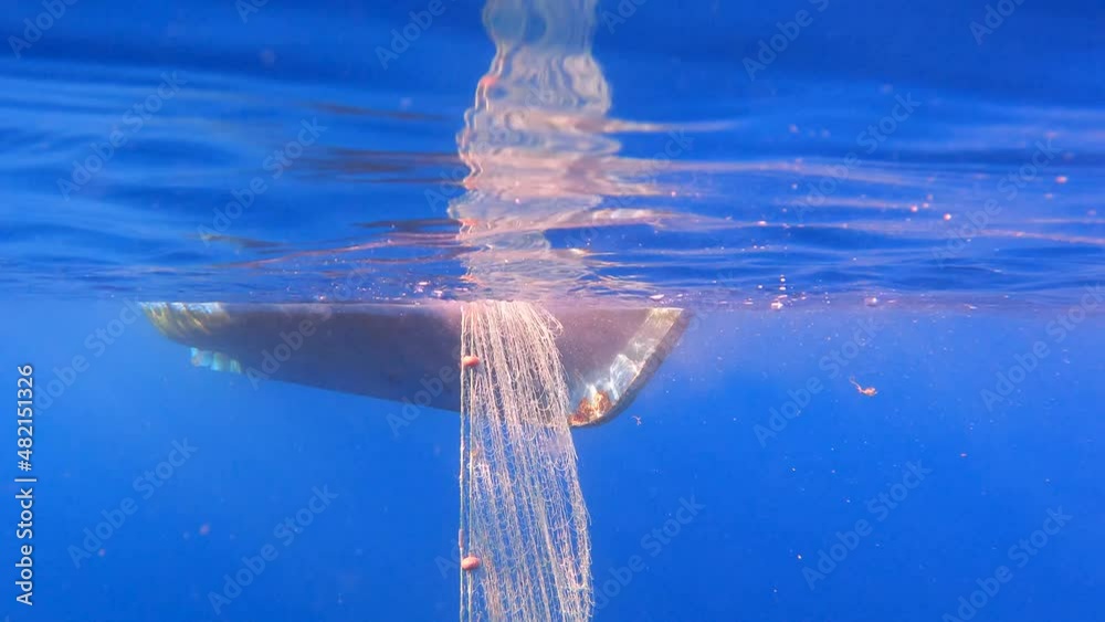 4K.Fishing net hanging from the boat under the sea.Underwater fishing ...
