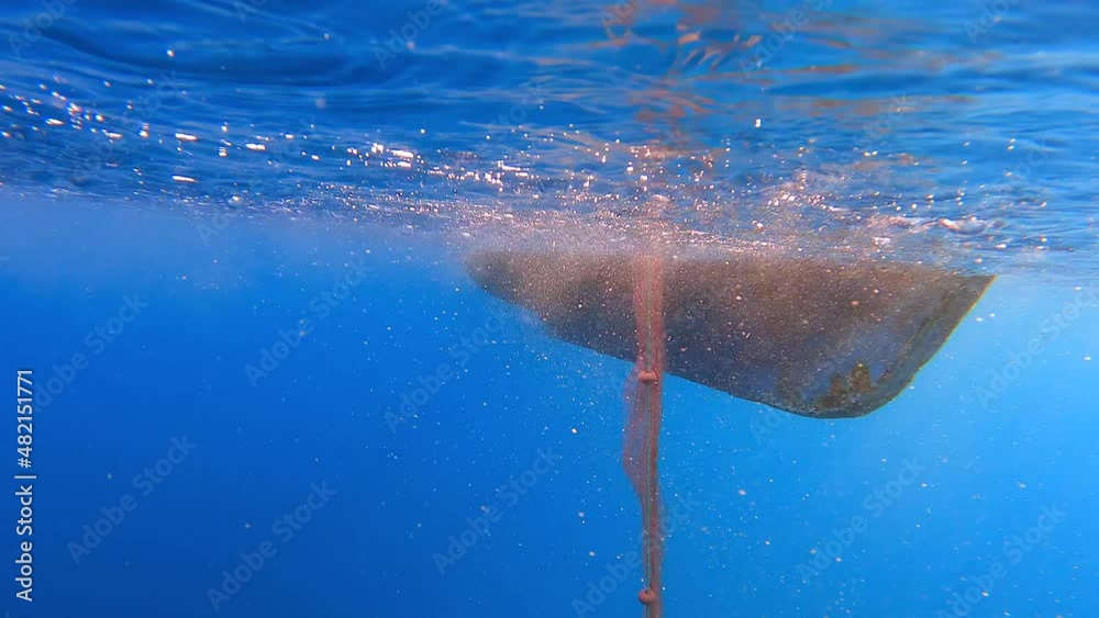 4K.Fishing net hanging from the boat under the sea.Underwater fishing ...