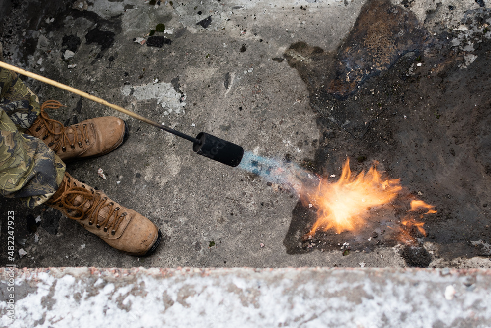 Downpipe repair. Heating the gutter area with a gas burner during ...