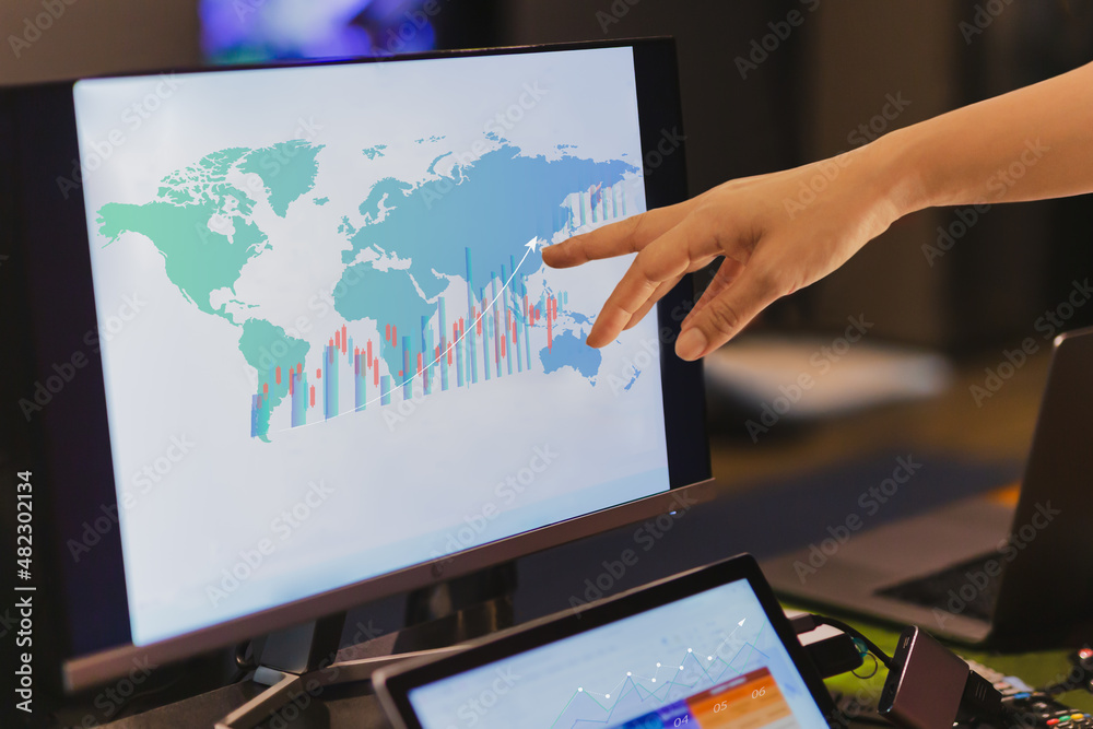 Business financial hand pointing on desktop computer screen with ...