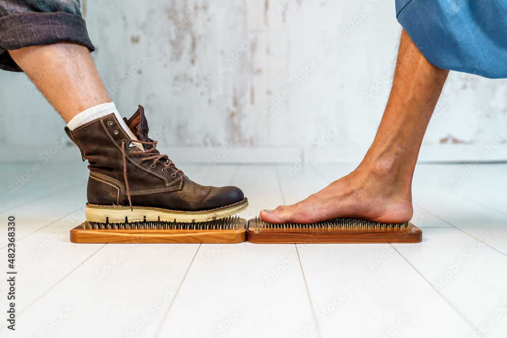 The practice of standing on nails. Close-up of a sadhu wooden board ...