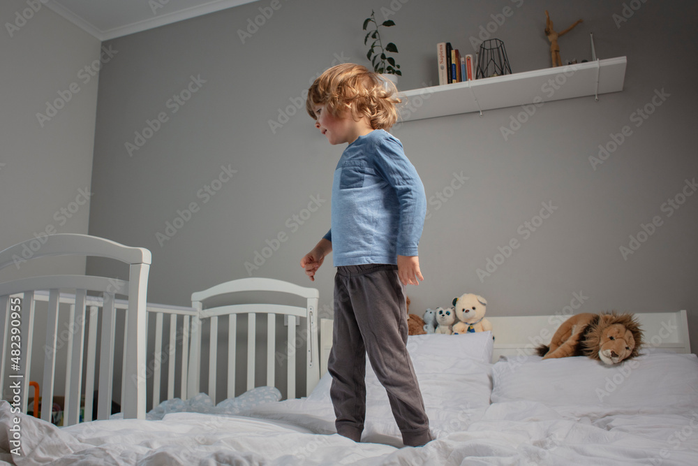 Child jumping on the parent's bed. Funny toddler. Playing baby. Baby in ...