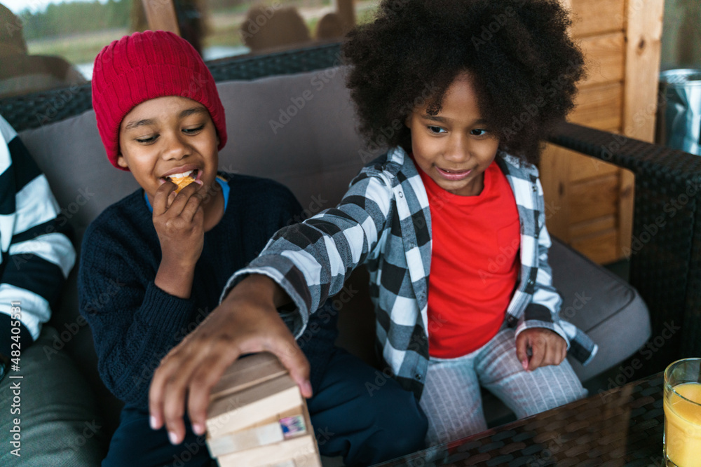 Black boys eating chips while playing jenga game Stock Photo | Adobe Stock