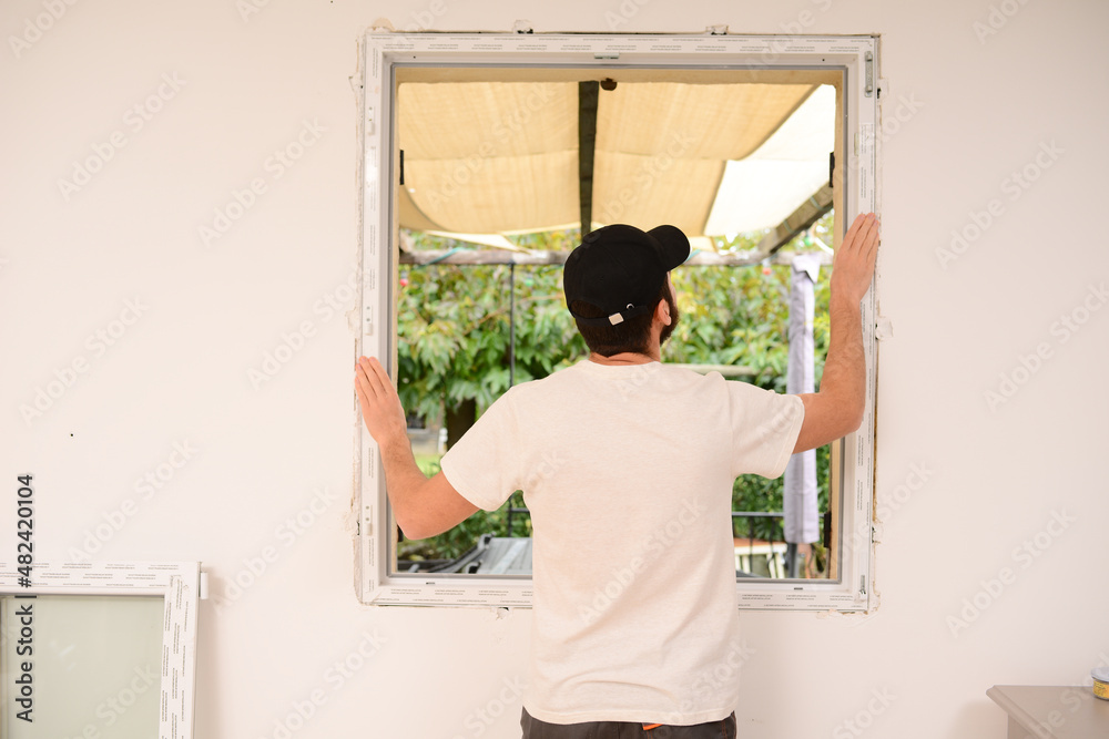 handsome young professional man installing and replacing a new home ...