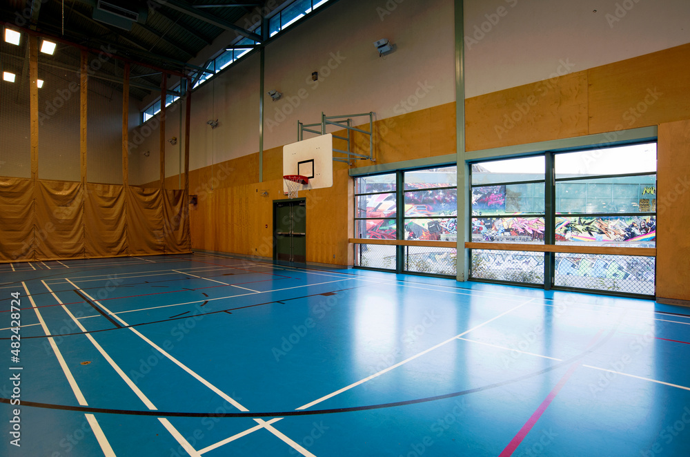 Spacious gymnasium with a basketball court floor markings, light and ...