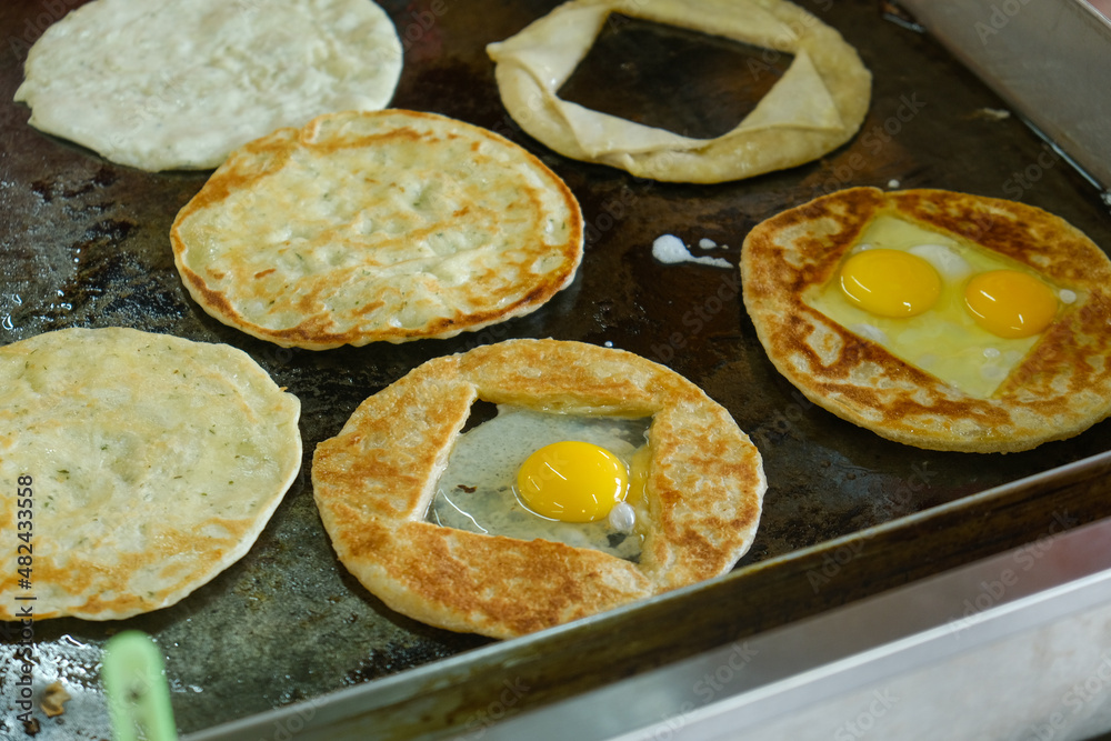 Selective focus picture of raw egg at paratha with other paratha ...