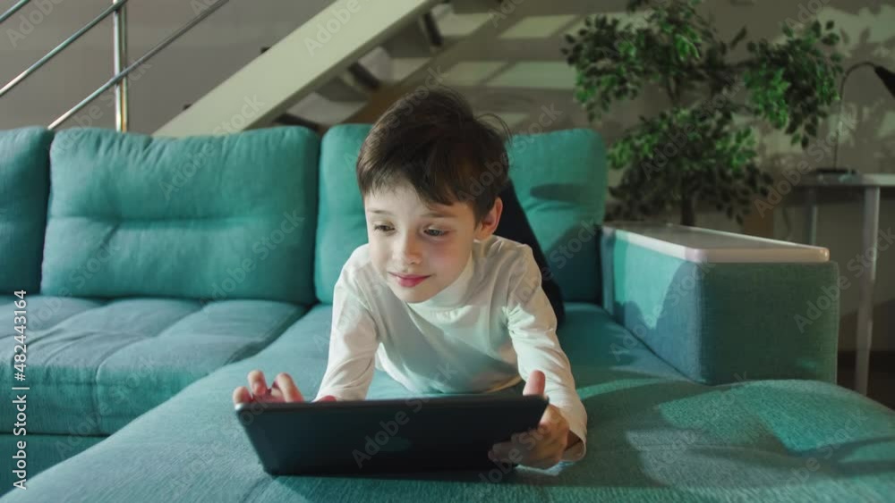 Vidéo Stock Curious Child Little school Boy Using Digital Tablet ...