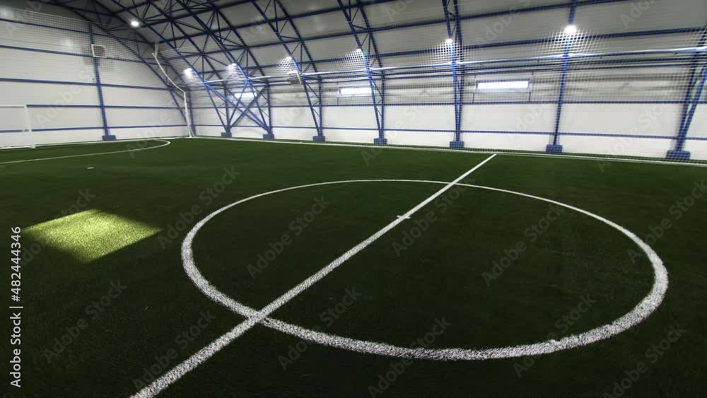 Empty indoor football field with fresh white marking under semi ...