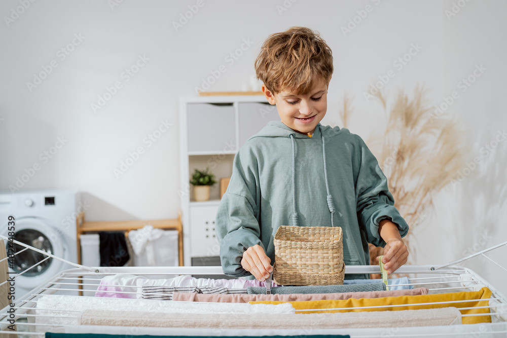 Smiling boy spends time in bathroom, laundry room placing clips on ...
