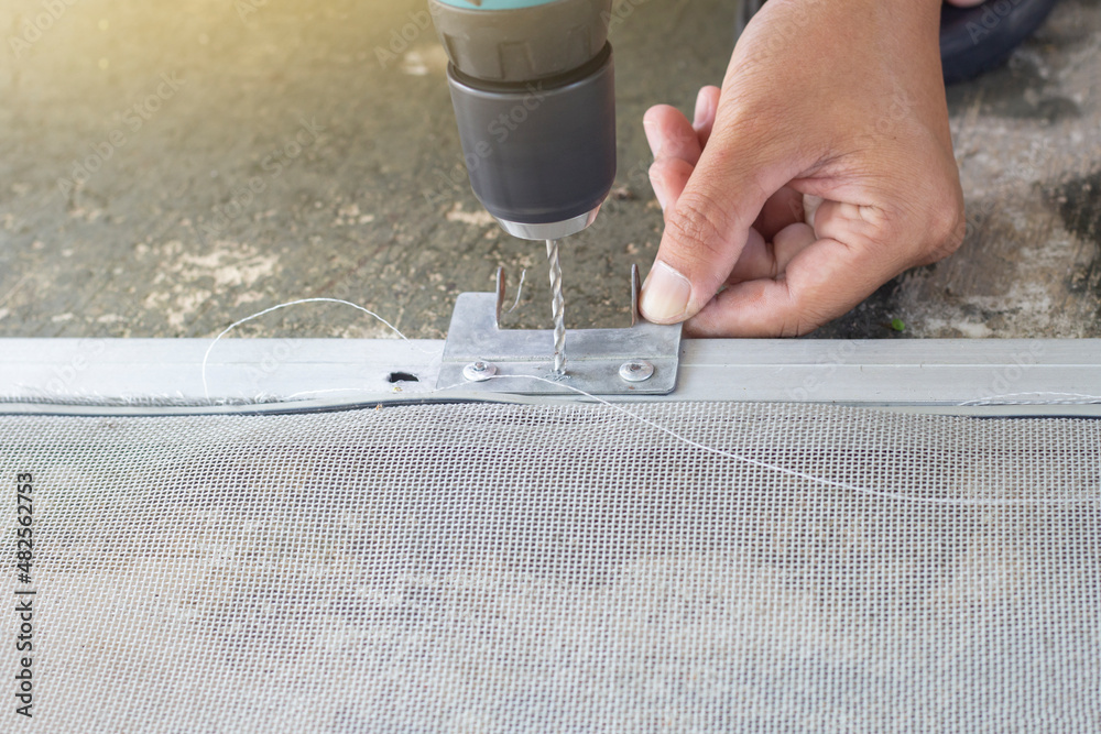 Mechanic uses automatic screwdriver to drill aluminum sheet to fix the ...