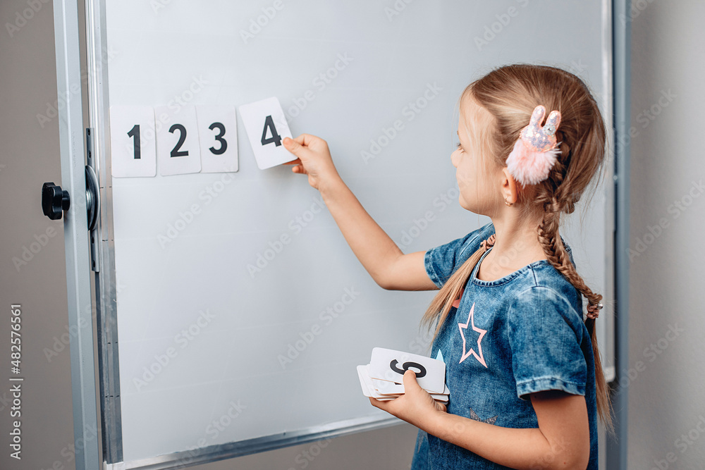 Little cute puppet girl child arranging numbers in the correct order ...