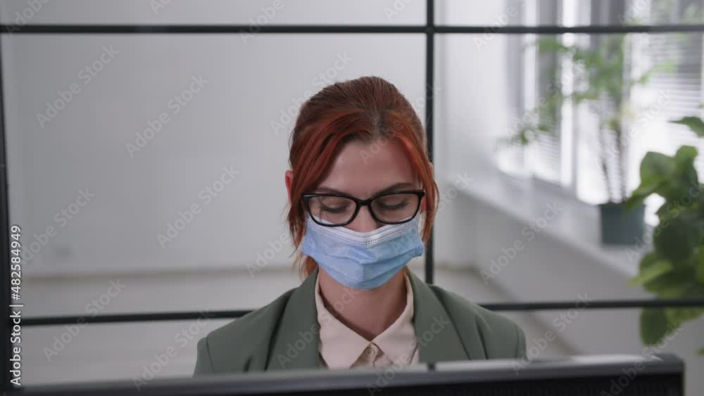 pandemic work, young female employee wearing medical mask on her face ...