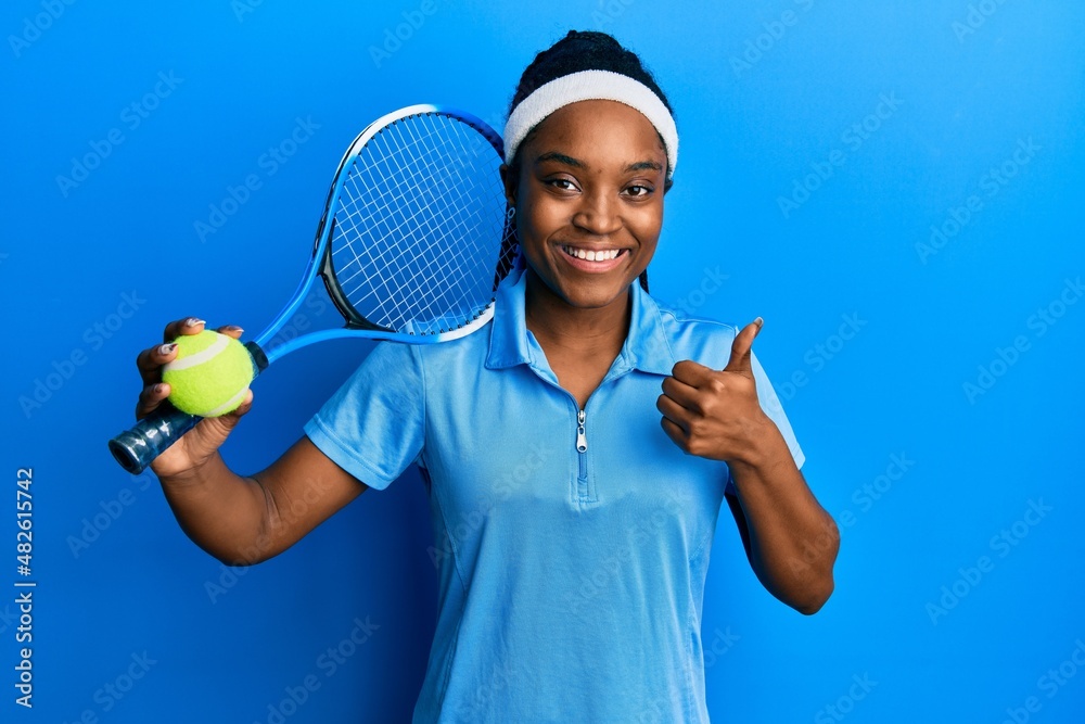 African american woman with braided hair playing tennis holding racket ...