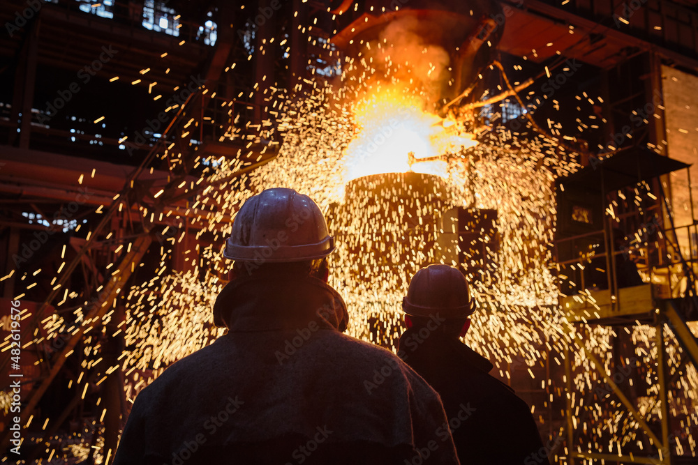 Metallurgists during the process of pouring steel from a ladle. Ingot ...