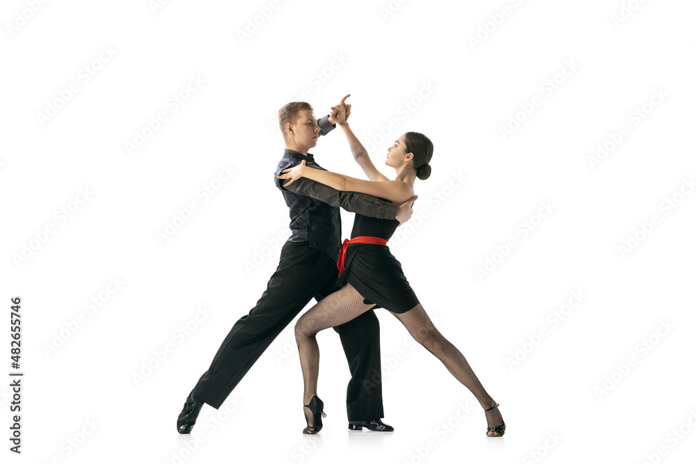 Flexible young couple dancing Argentine tango isolated on white studio background. Artists in ...