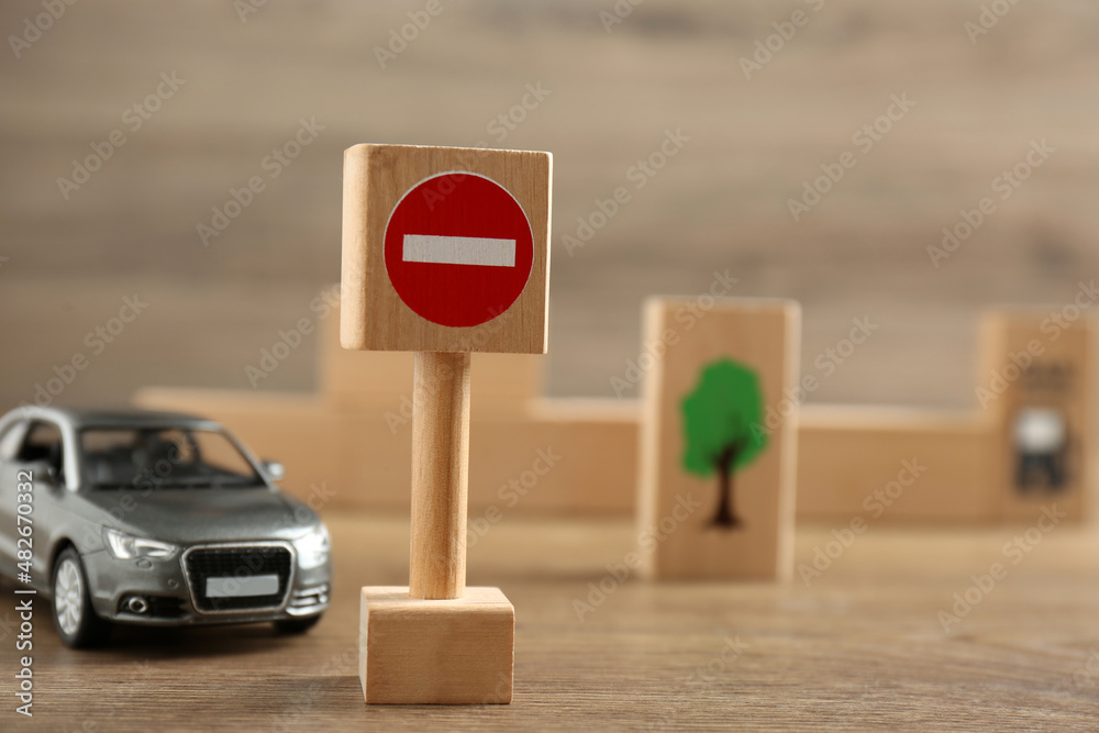 Traffic sign No entry and toy car on wooden table. Passing driving ...