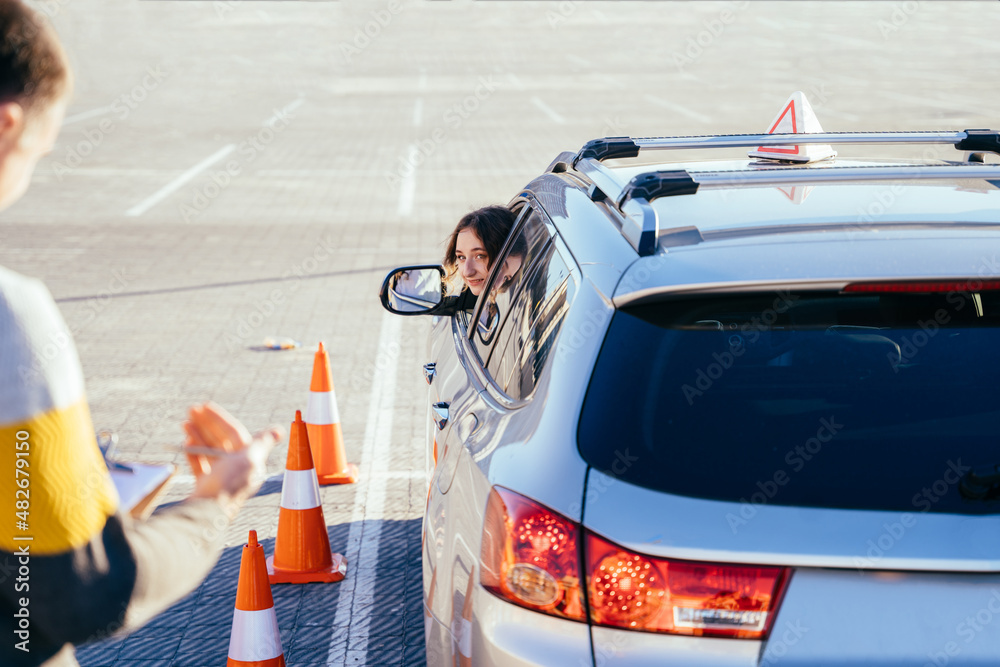 Male instructor teaching learner driver to park a car. Instructor and ...