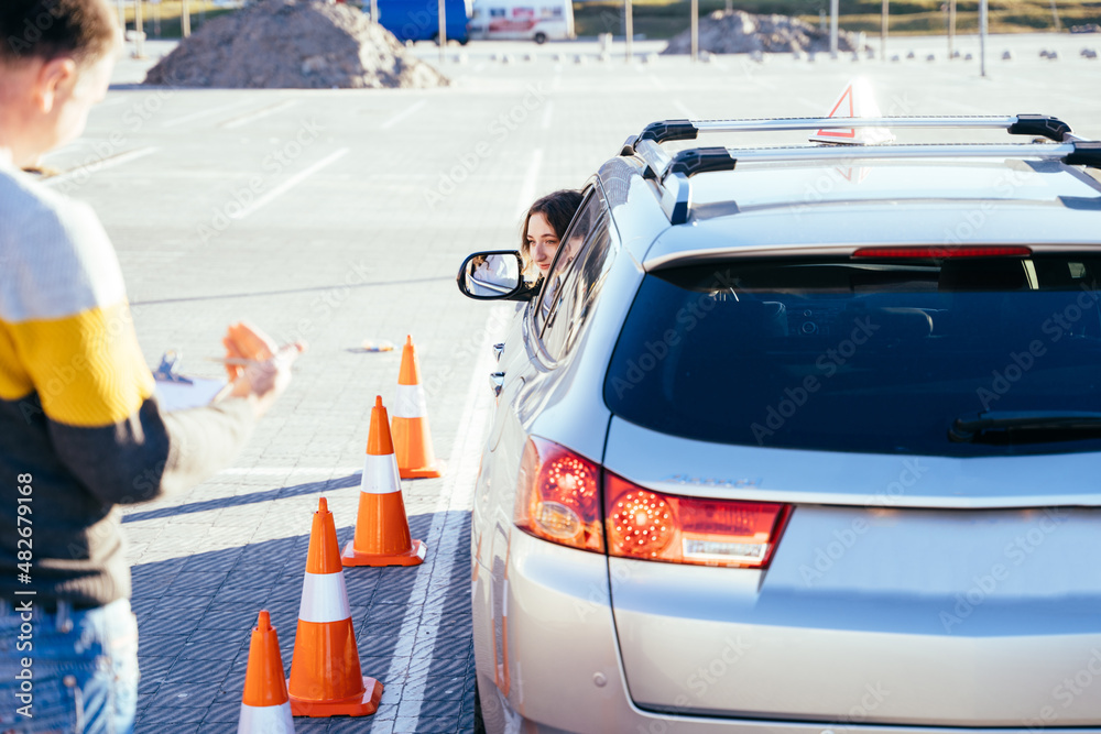 Male instructor teaching learner driver to park a car. Instructor and ...
